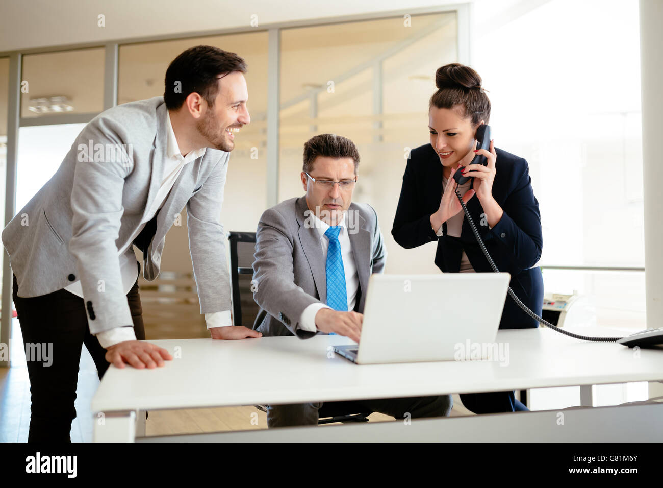 Secretaries assisting boss at business in office Stock Photo - Alamy