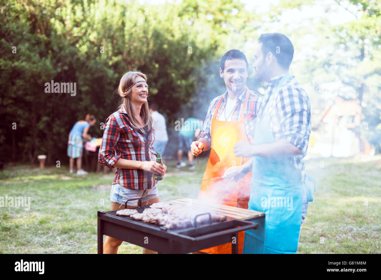 Young people enjoying barbecuing Stock Photo - Alamy