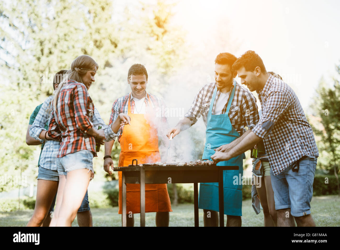 Young people enjoying barbecuing Stock Photo - Alamy