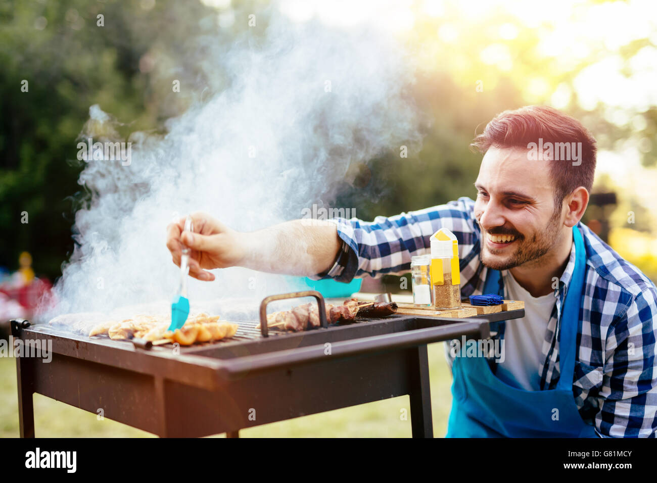 HAndsome male preparing barbecue outdoors for friends Stock Photo - Alamy