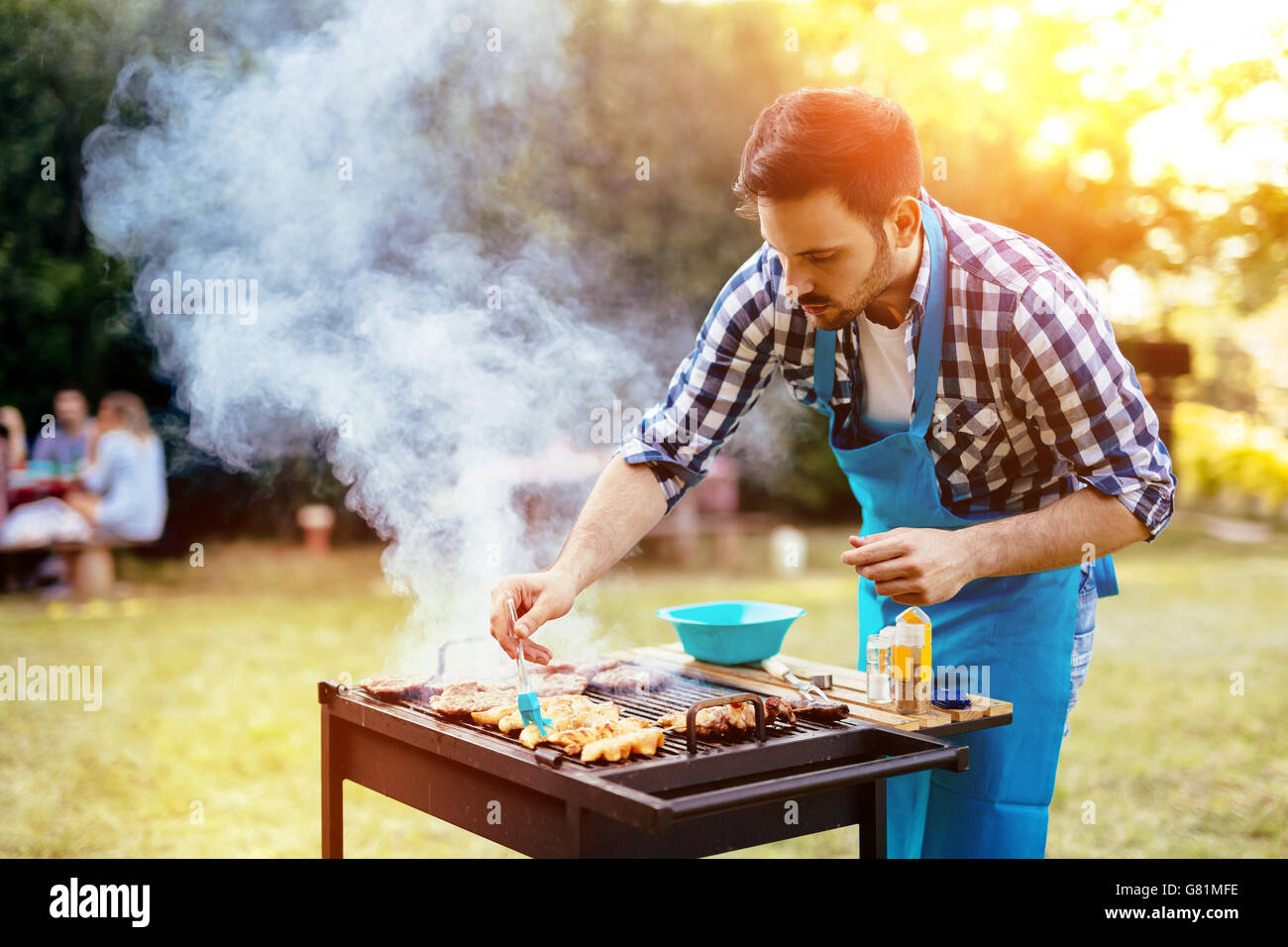 HAndsome male preparing barbecue outdoors for friends Stock Photo - Alamy