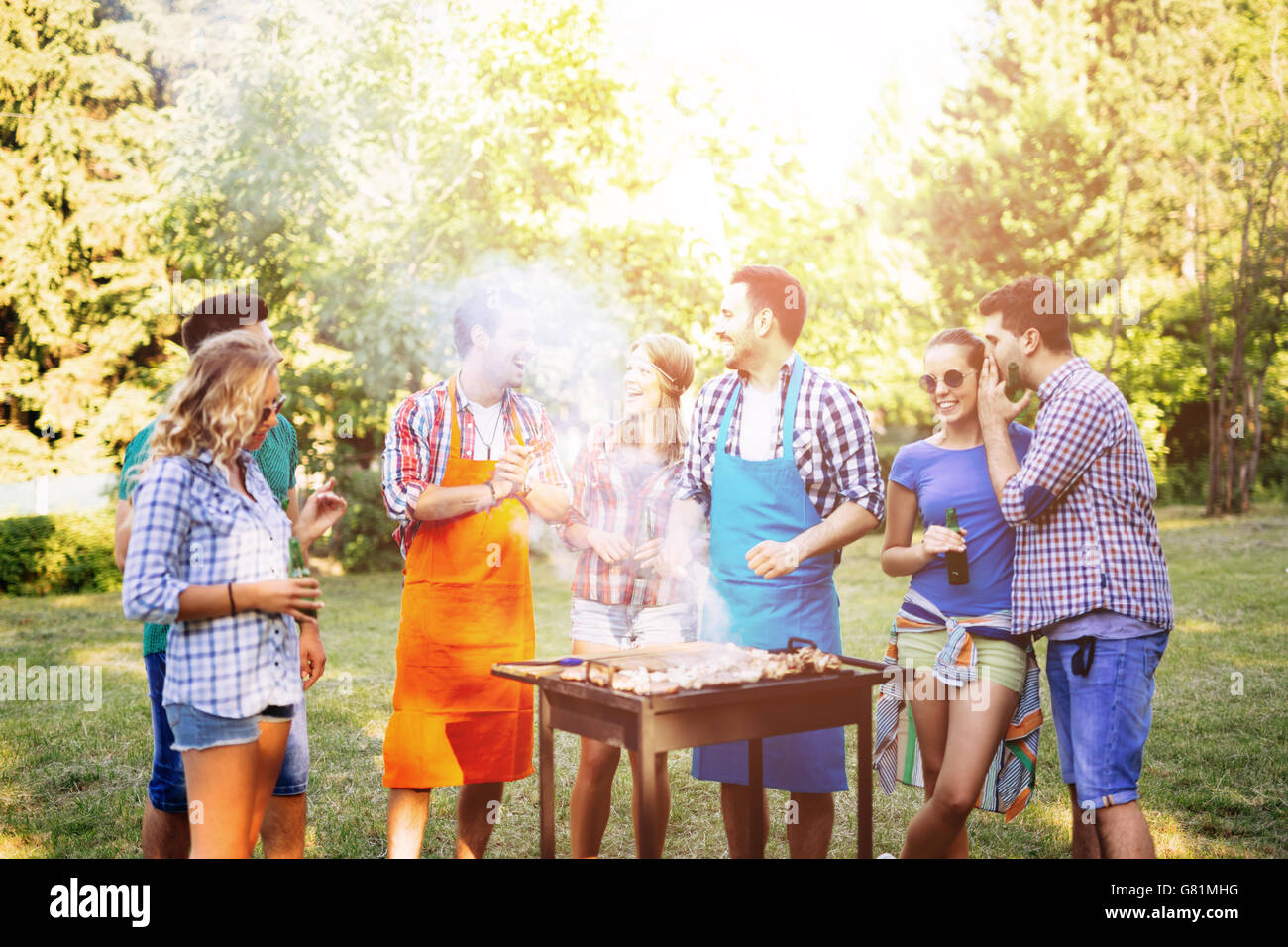 Young people enjoying barbecuing Stock Photo - Alamy