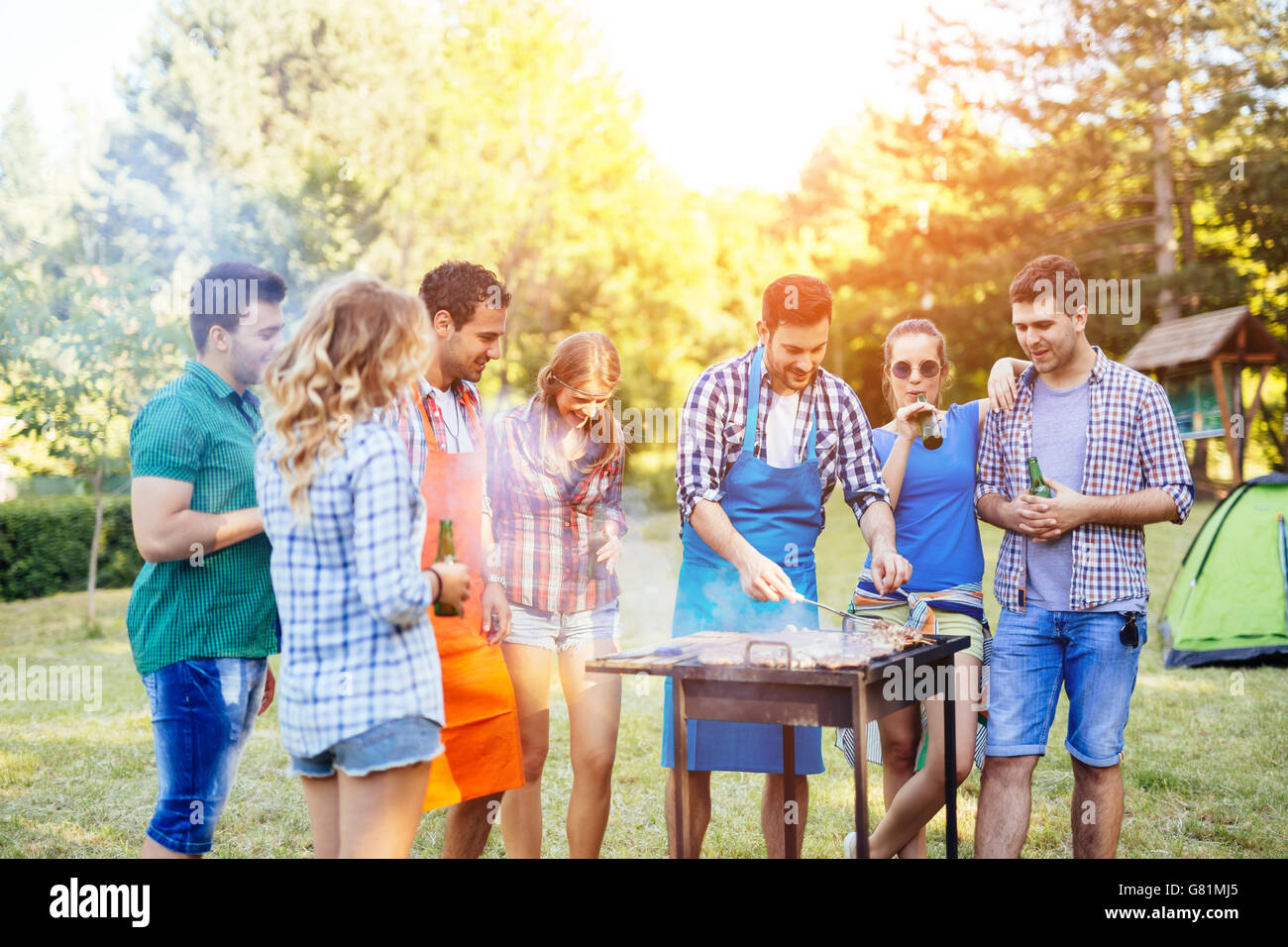 Friends having a barbecue party in nature while having a blast Stock ...