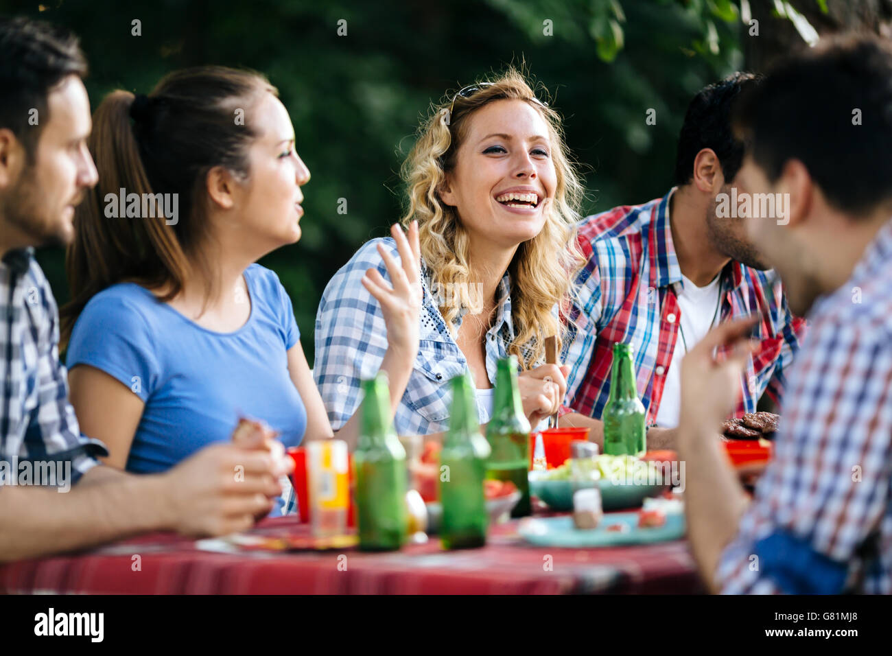 Friends eating outdoors and having fun after barbecuing Stock Photo - Alamy