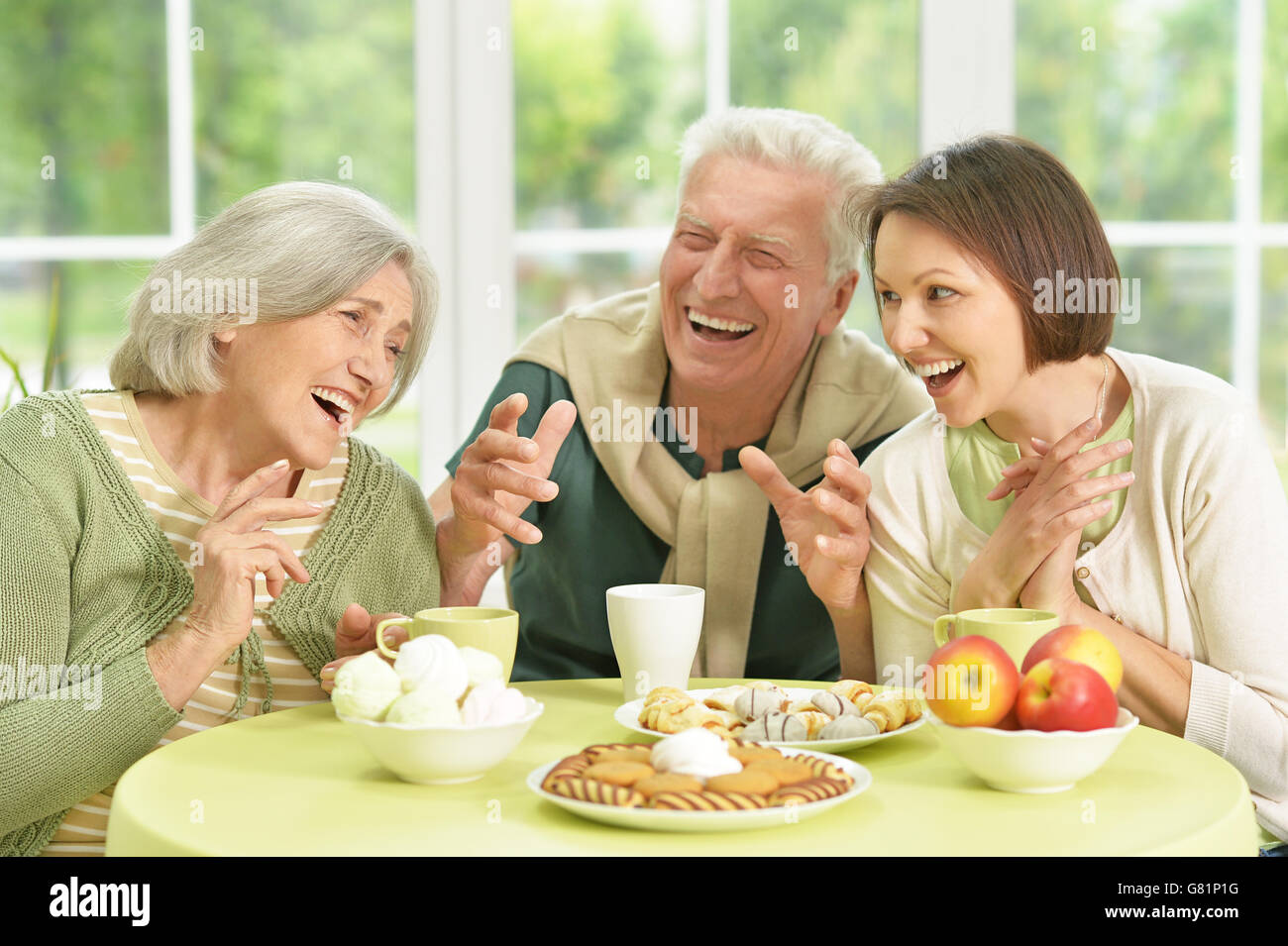 daughter with senior parents drinkig tea Stock Photo - Alamy
