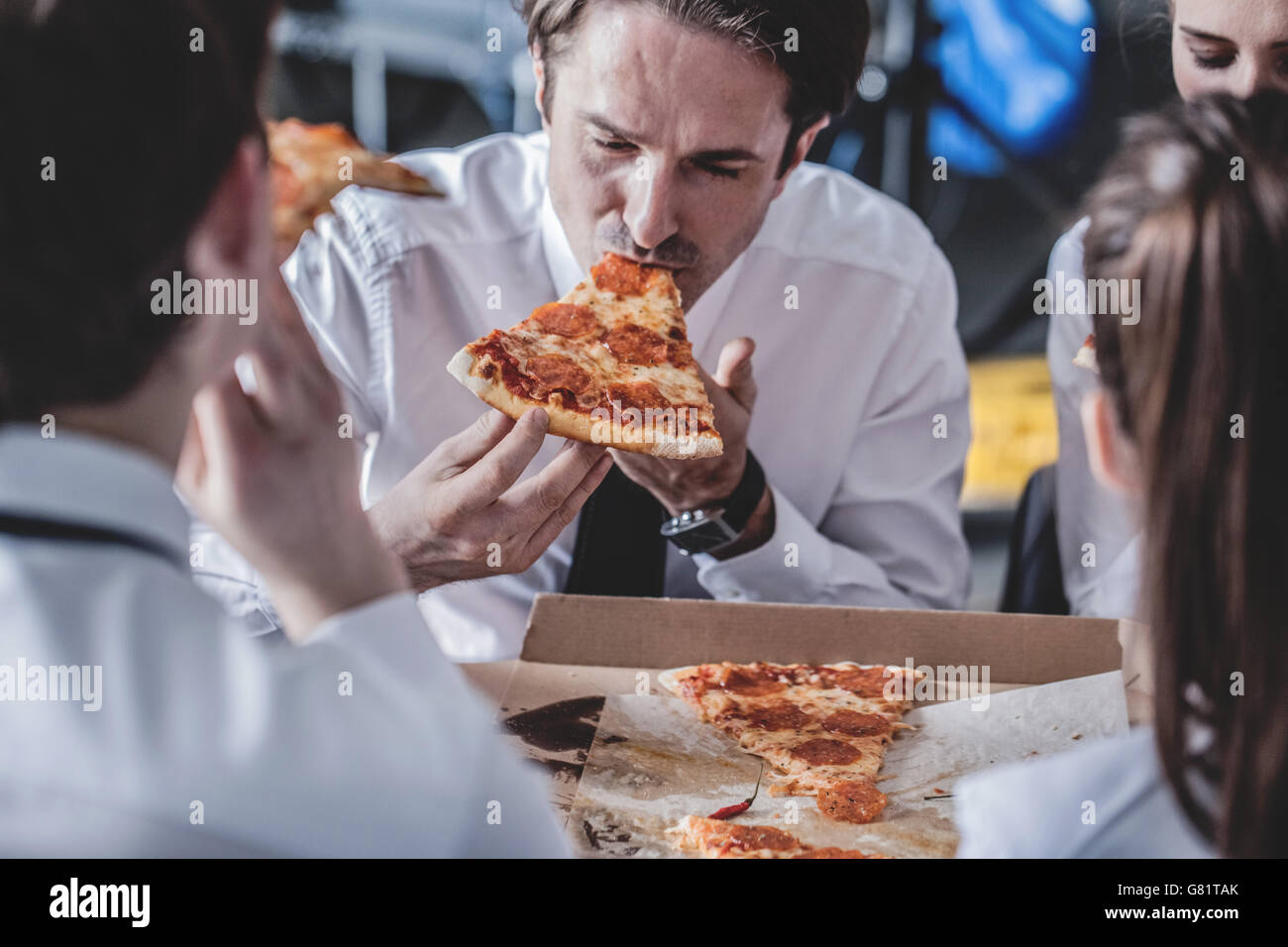 Business team eating pizza in office sitting around the table Stock ...