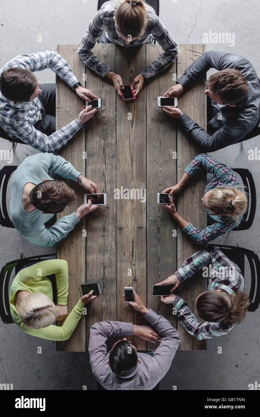 Hipster people sitting around the table with smartphones Stock Photo ...