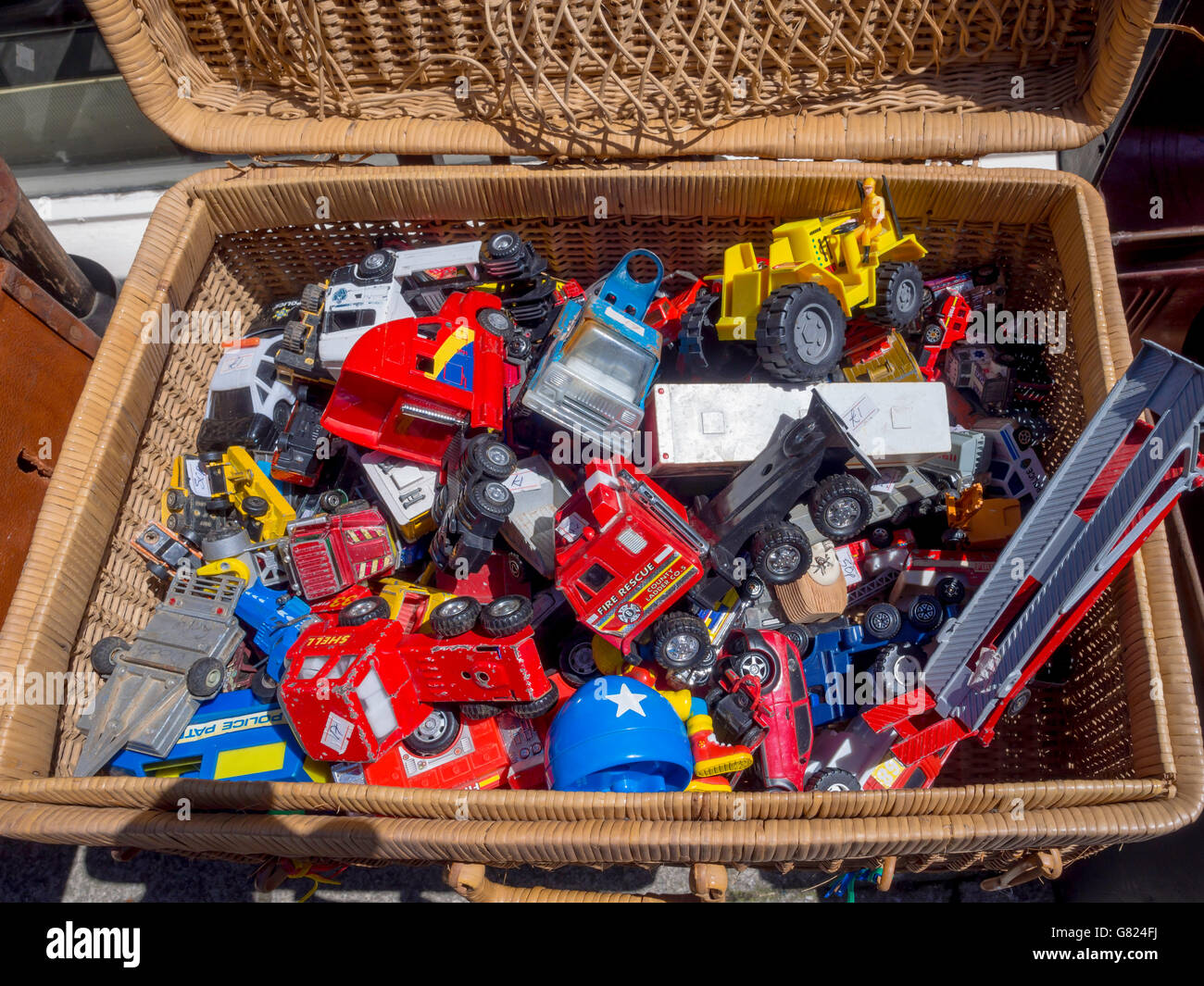 A collection of assorted vintage toy vehicles in a basket in an English ...