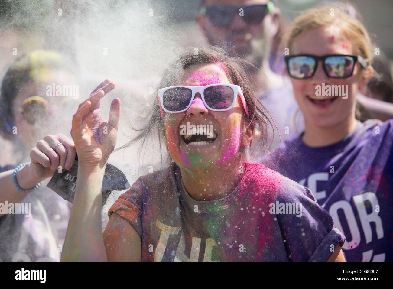 Volunteers throw colourful powder onto runners at the Color Run at ...