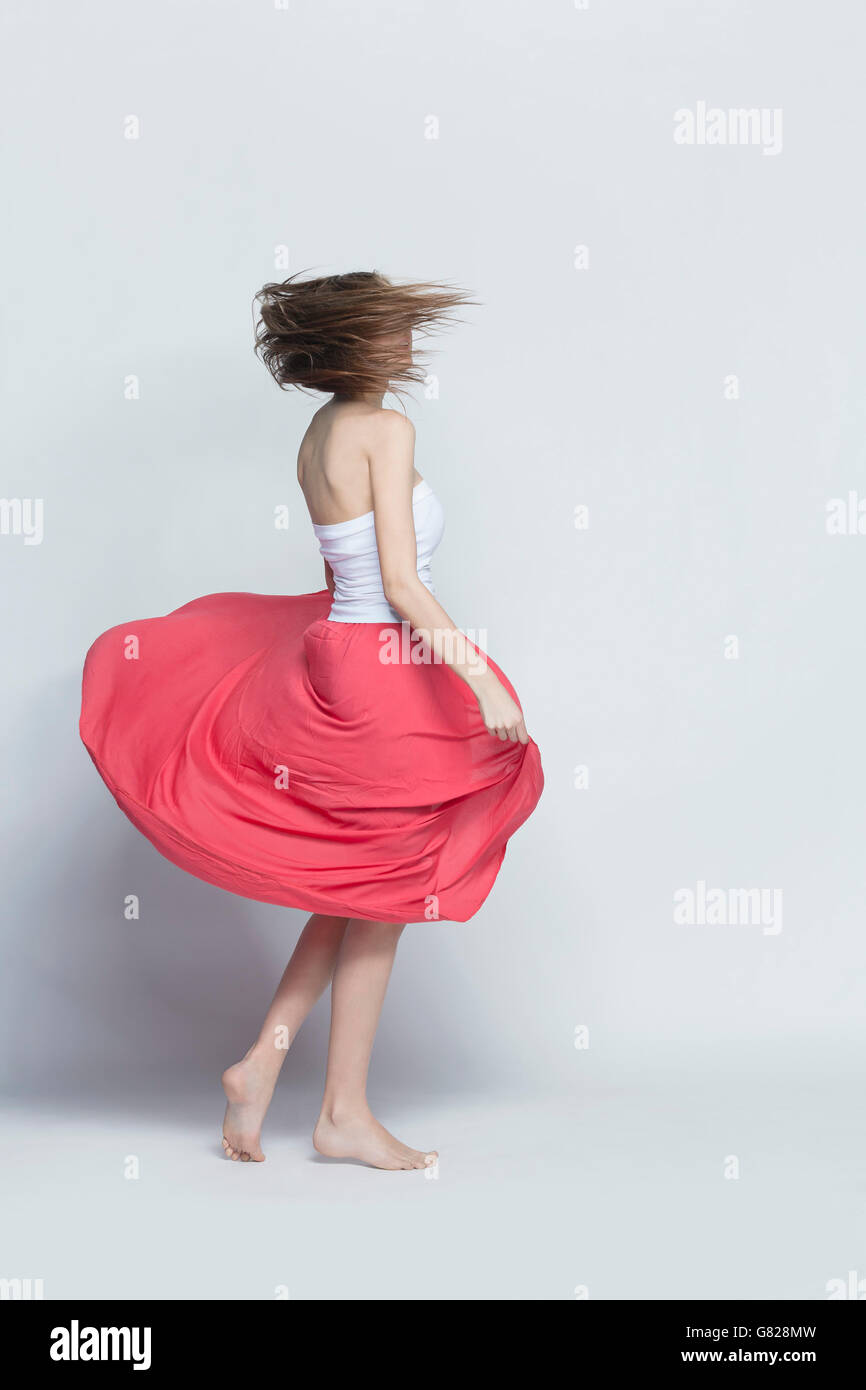 Young woman spinning against white background Stock Photo - Alamy