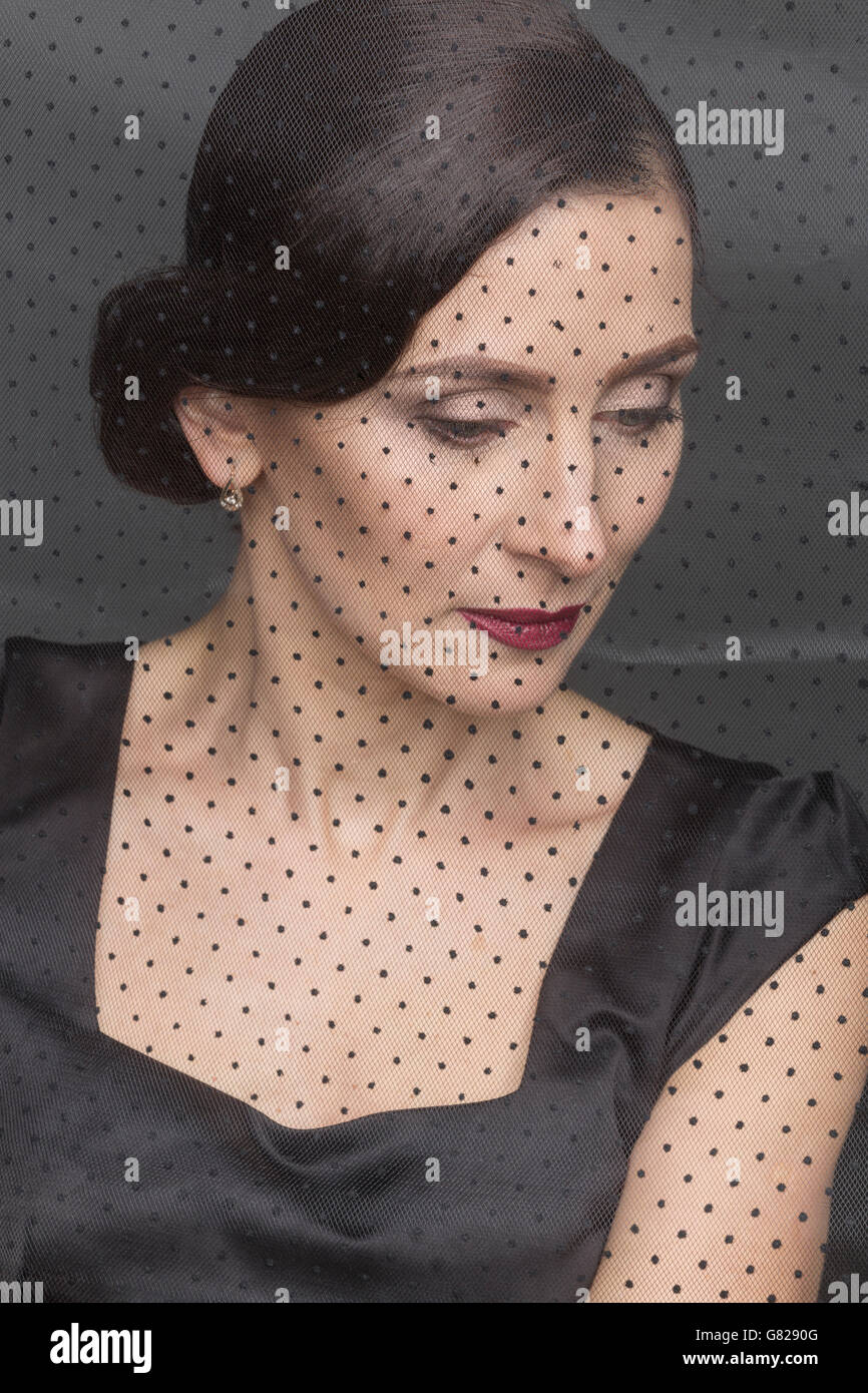 Beautiful woman in black dress seen through net Stock Photo - Alamy
