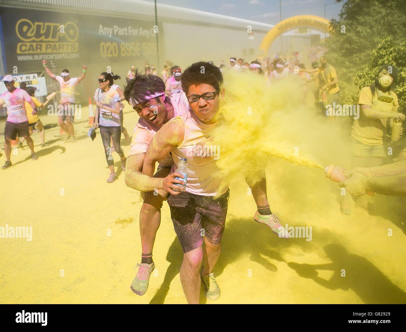 Volunteers throw colourful powder on runners during the Color Run at ...