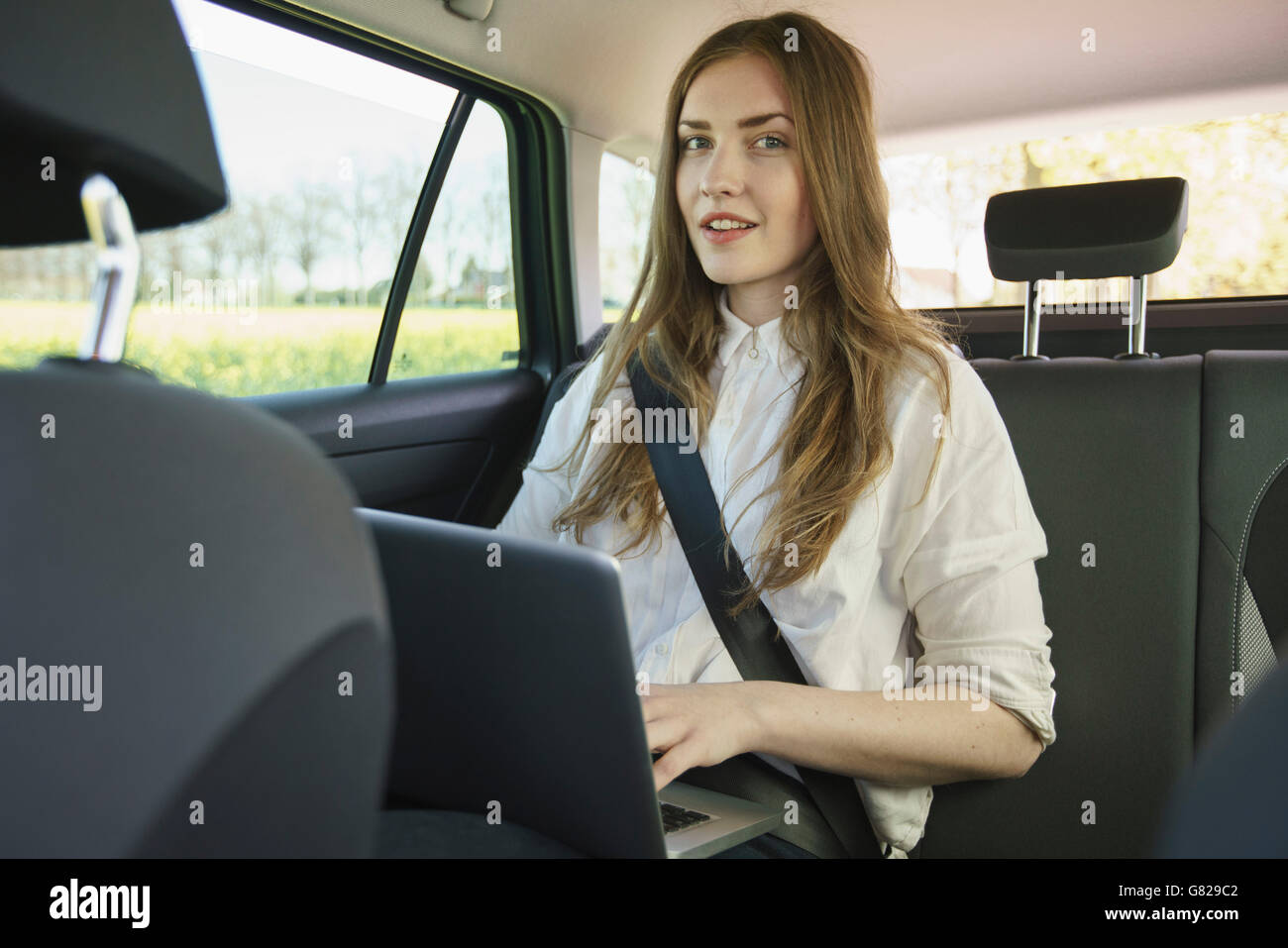 Portrait of businesswoman using laptop in car Stock Photo - Alamy