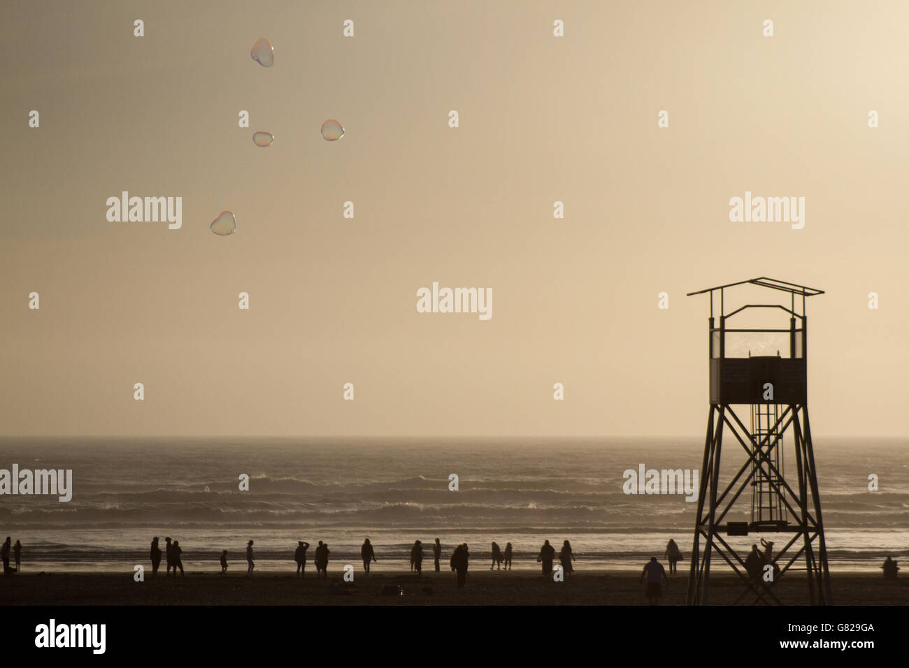 Giant bubbles float over the water at Seaside as beachgoers enjoy the ...