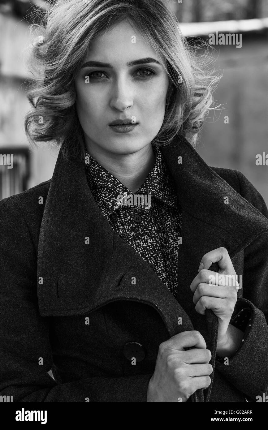 Portrait Of Beautiful Young Woman Wearing Long Coat Outdoors Stock