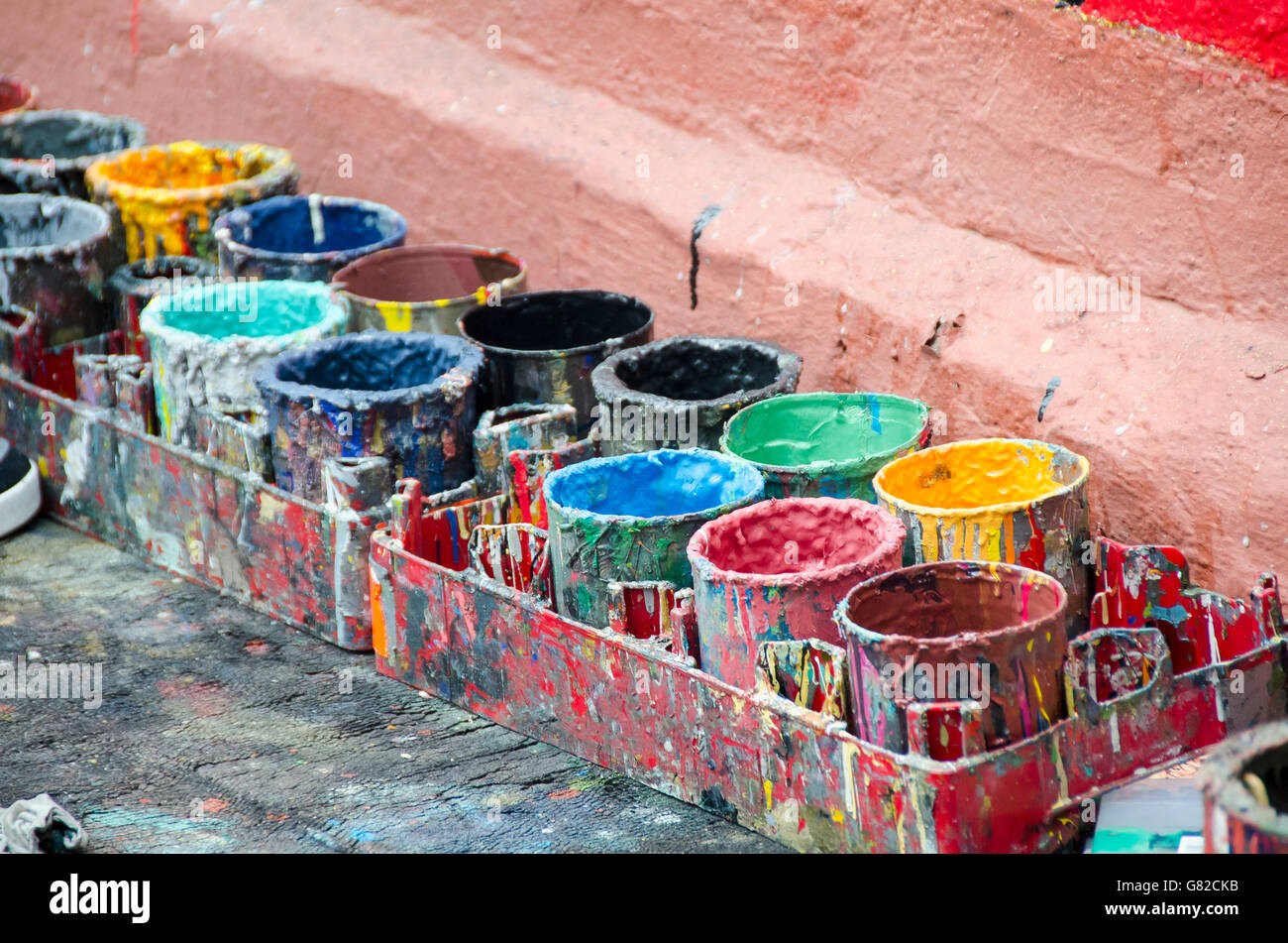 High angle view of colorful paint cans by wall Stock Photo - Alamy