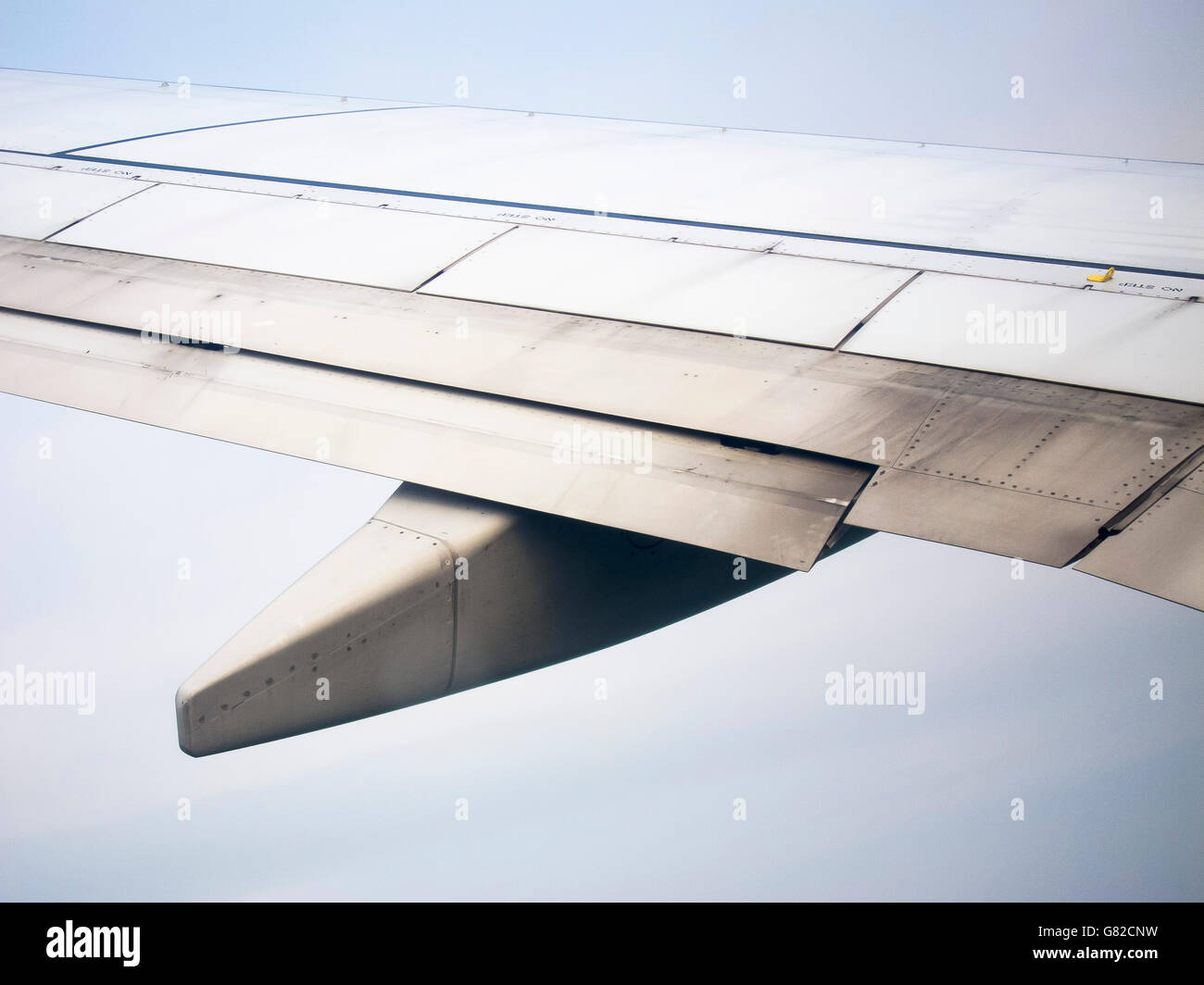 Cropped image of airplane wing flying in sky Stock Photo - Alamy
