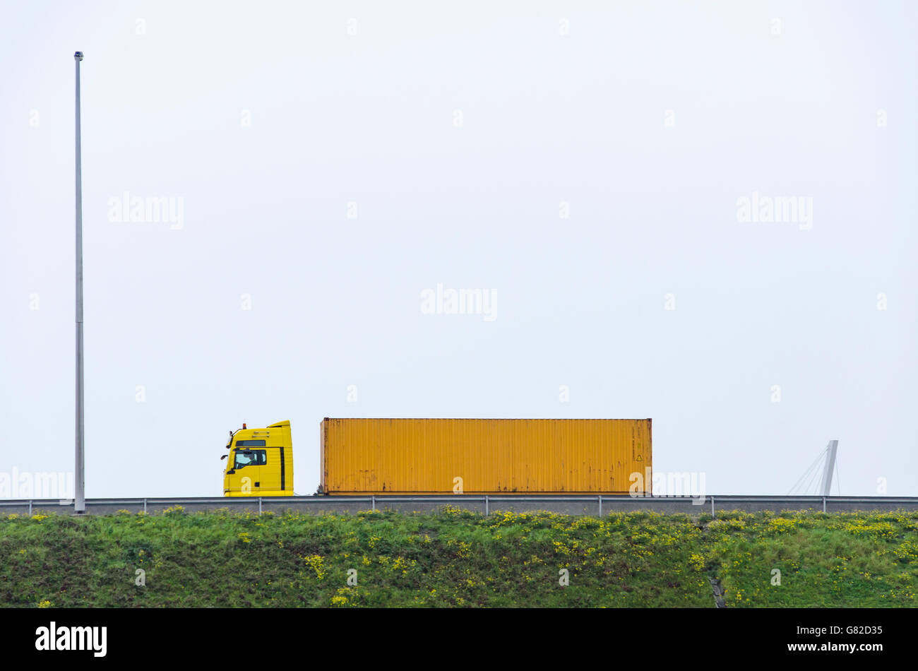 Yellow semi-truck on bridge against clear sky Stock Photo - Alamy