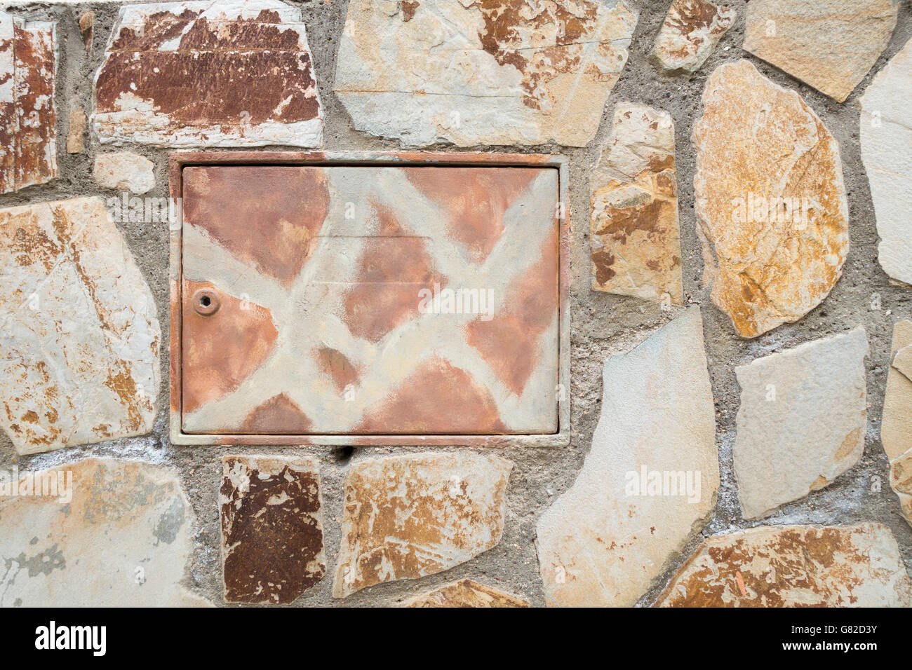 Rusty metal box in stone wall Stock Photo - Alamy