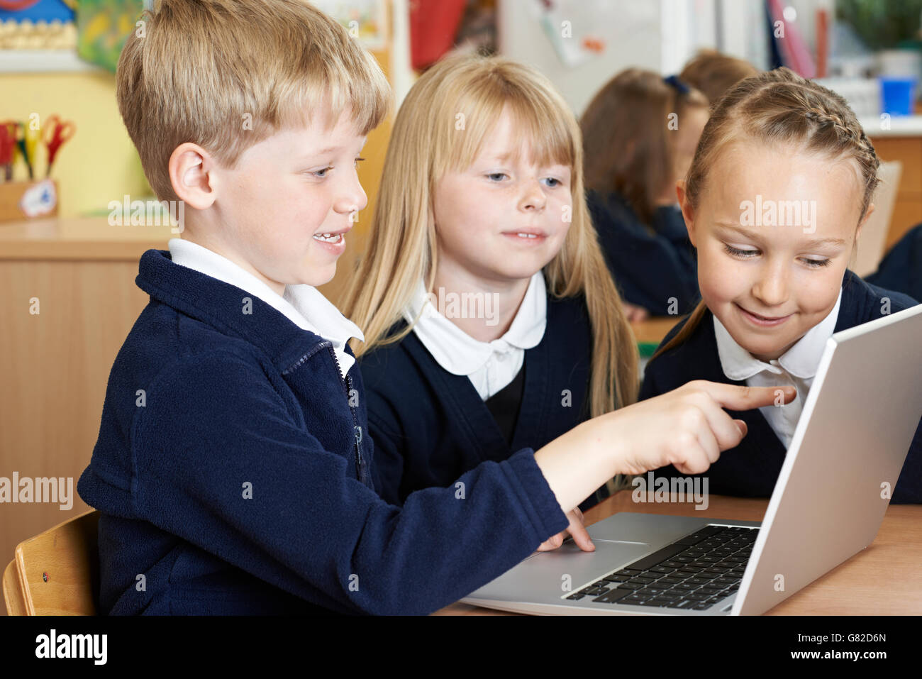 Group Of Elementary School Children Working Together In Computer Class ...
