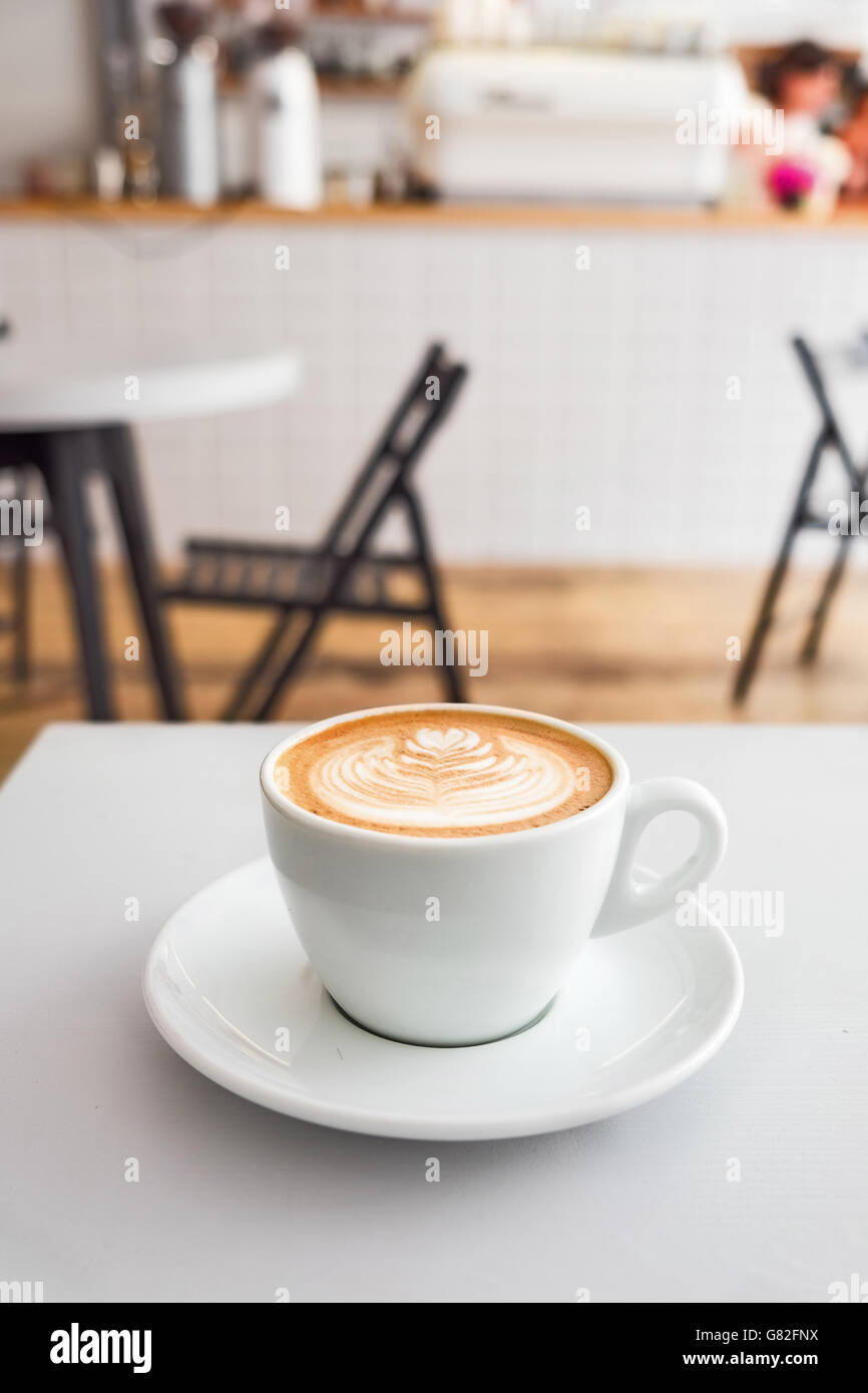Cappuccino with milk foam art pattern on a white table with a coffee ...