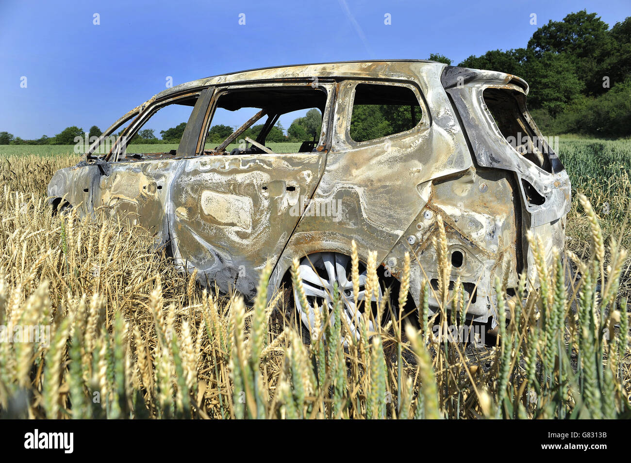 A burnt out vehicle dumped in a field in Navestock, Essex Stock Photo ...