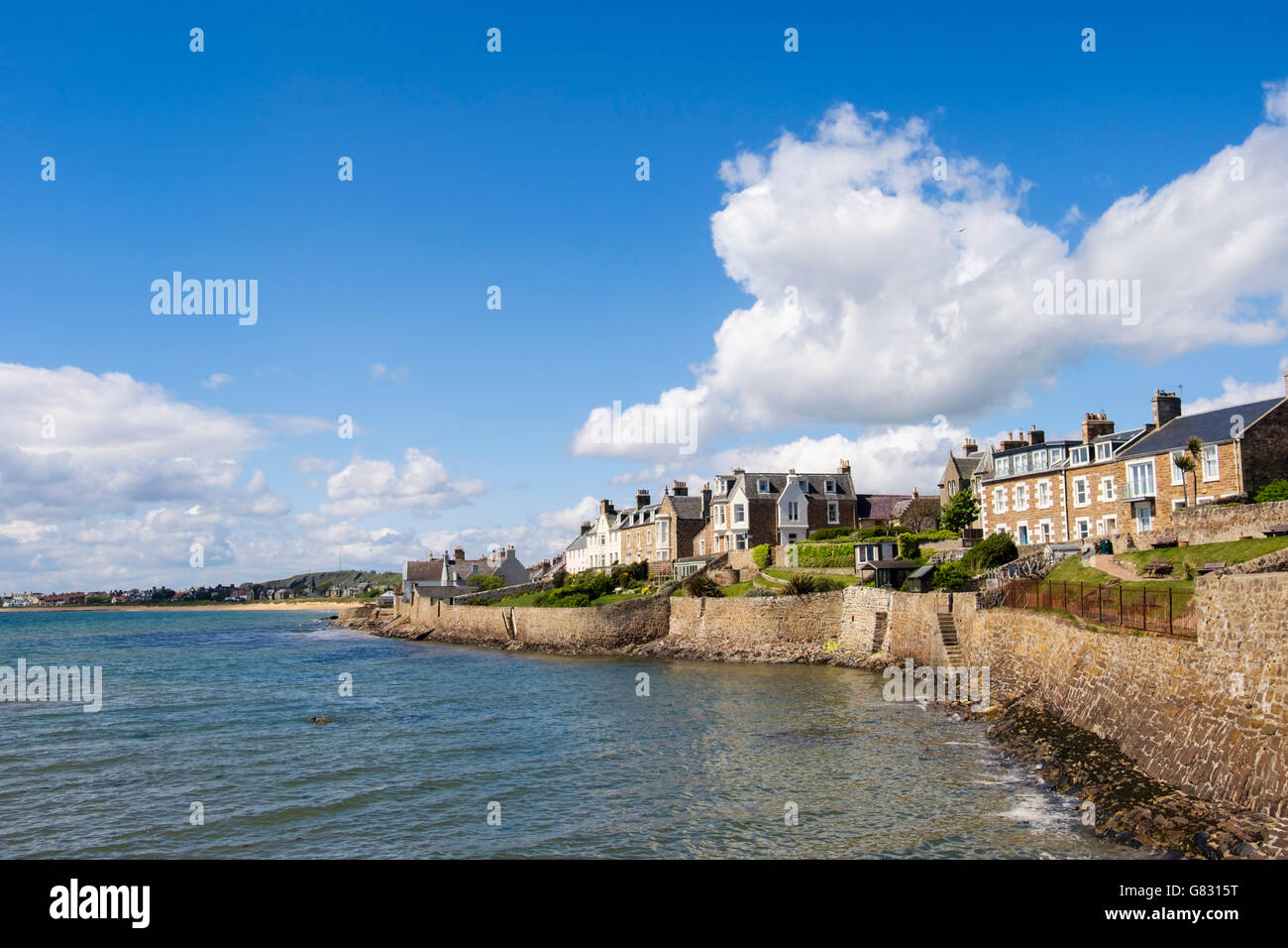 Seafront buildings above seawall at high tide in village on Firth of ...