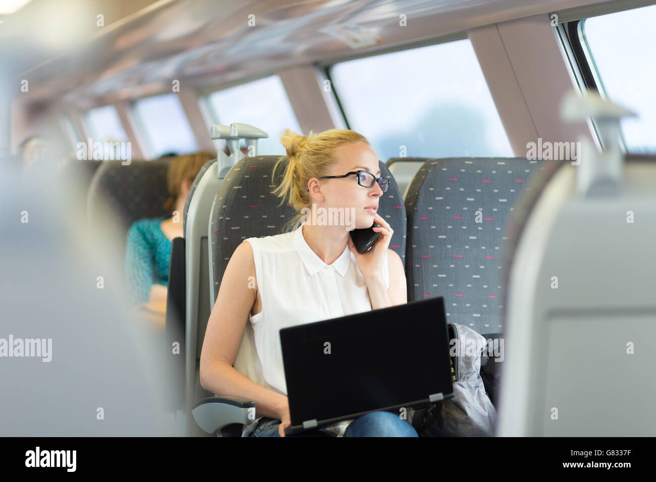 Business woman working while travelling by train Stock Photo - Alamy