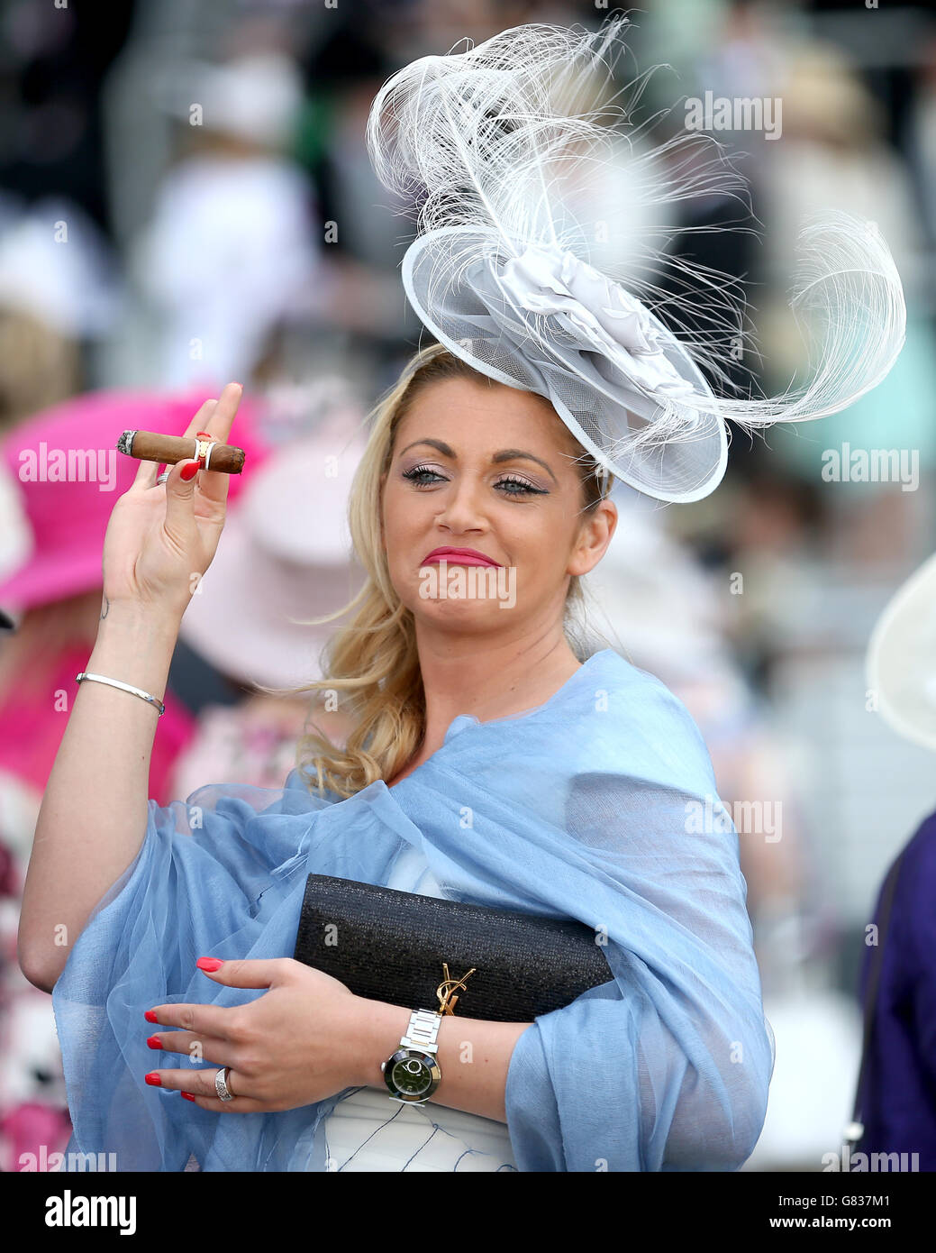 A racegoer enjoys a cigar during Ladies Day, on day three of the 2015 ...