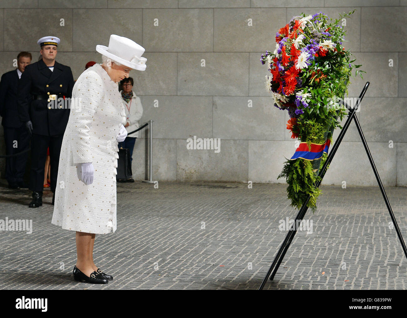 Queen Elizabeth II bows her head in silence after the laying of a ...