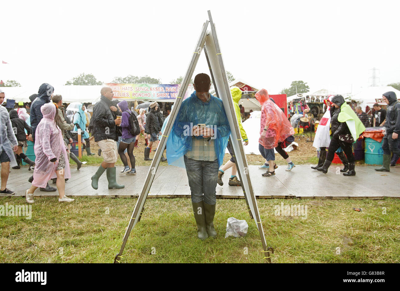 Festival Goers In The Rain At The Glastonbury Festival At Worthy Farm