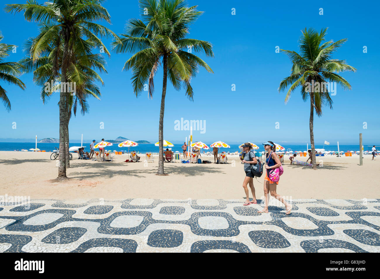 RIO DE JANEIRO - FEBRUARY 28, 2016: Beachgoers pass on the beachfront ...