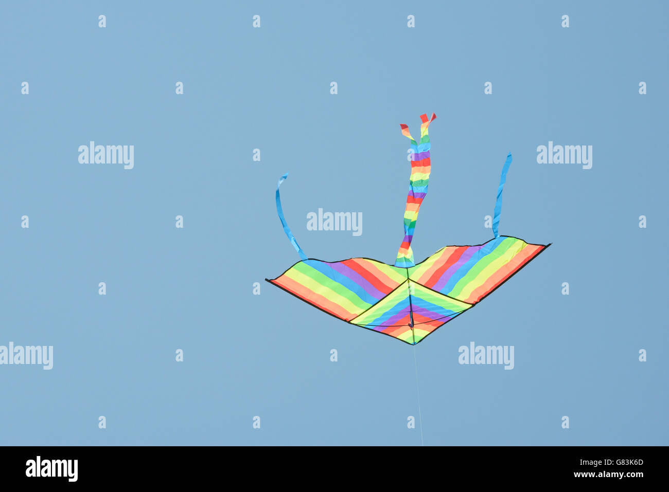 a nice multi color kite in the blue sky Stock Photo - Alamy