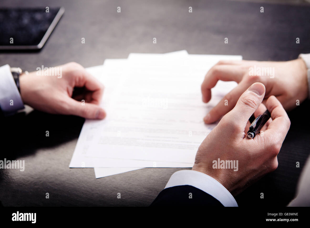 Closeup of male hand pointing where to sign a contract, legal papers or ...