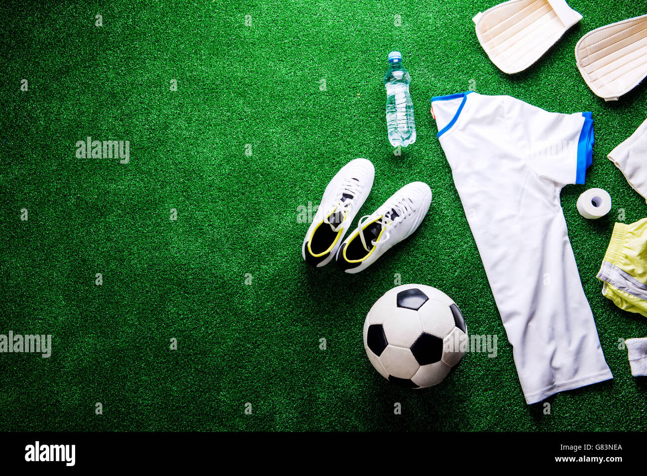 Soccer ball,cleats and various football stuff against artificial Stock ...