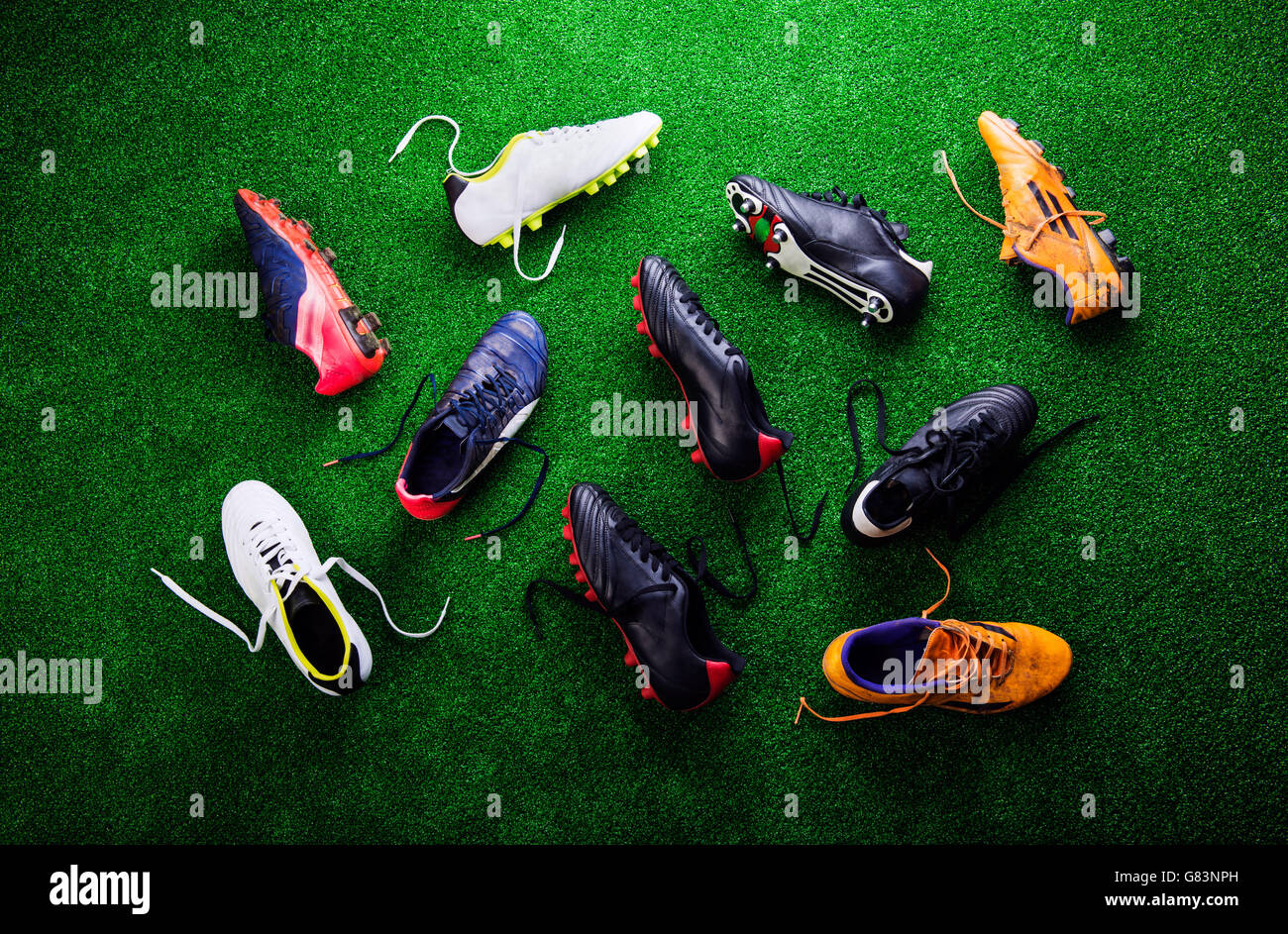 Various cleats against green artificial turf, studio shot Stock Photo ...