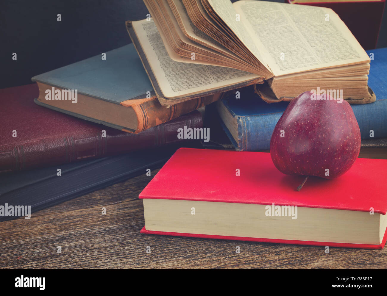 Bookshelf with books and apple Stock Photo - Alamy