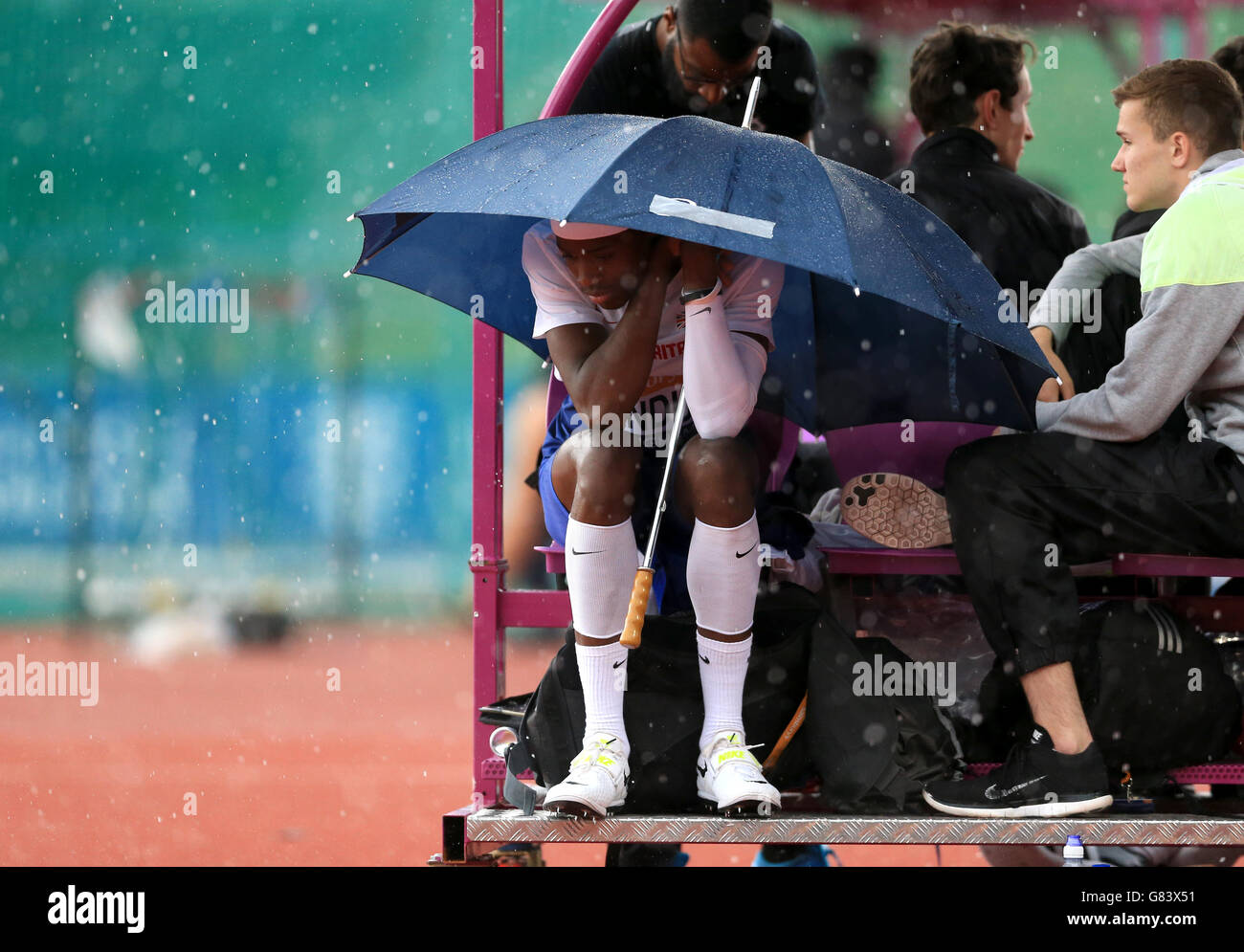Chris Kandu (Enfield) shelters from the rain under an umbrella during ...