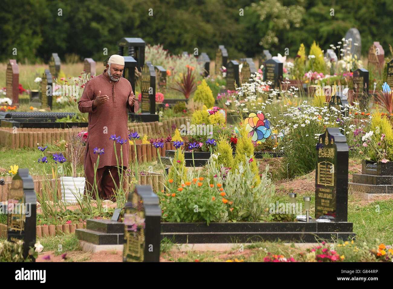 A man pays his respects at a grave in High Wood Cemetery in Bulwell ...