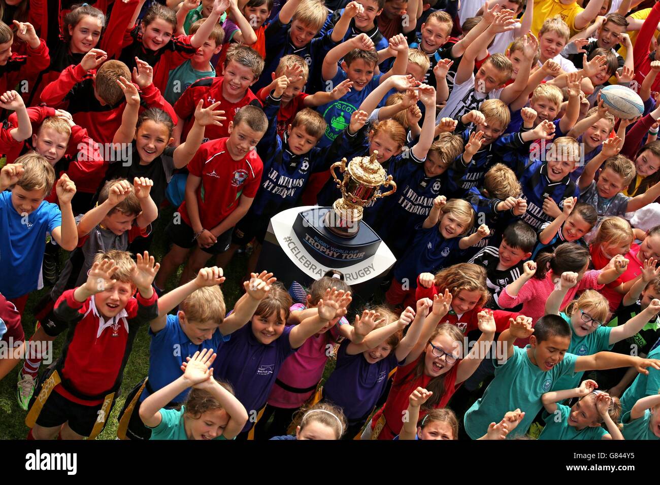 Children cheer as they surround the Webb Ellis Cup at a rugby festival ...
