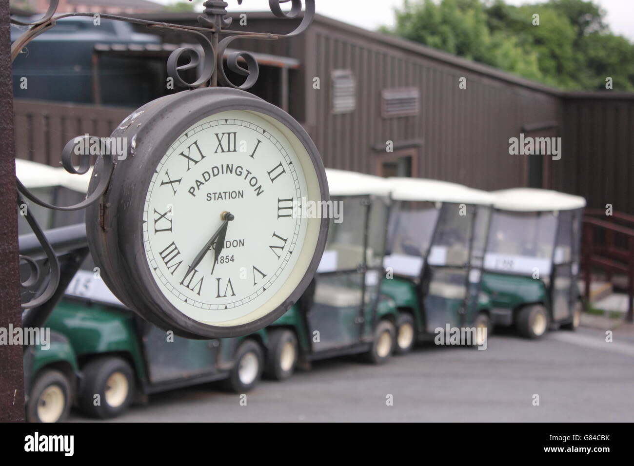 A clock on the first tee with golf buggies in the background on a golf ...