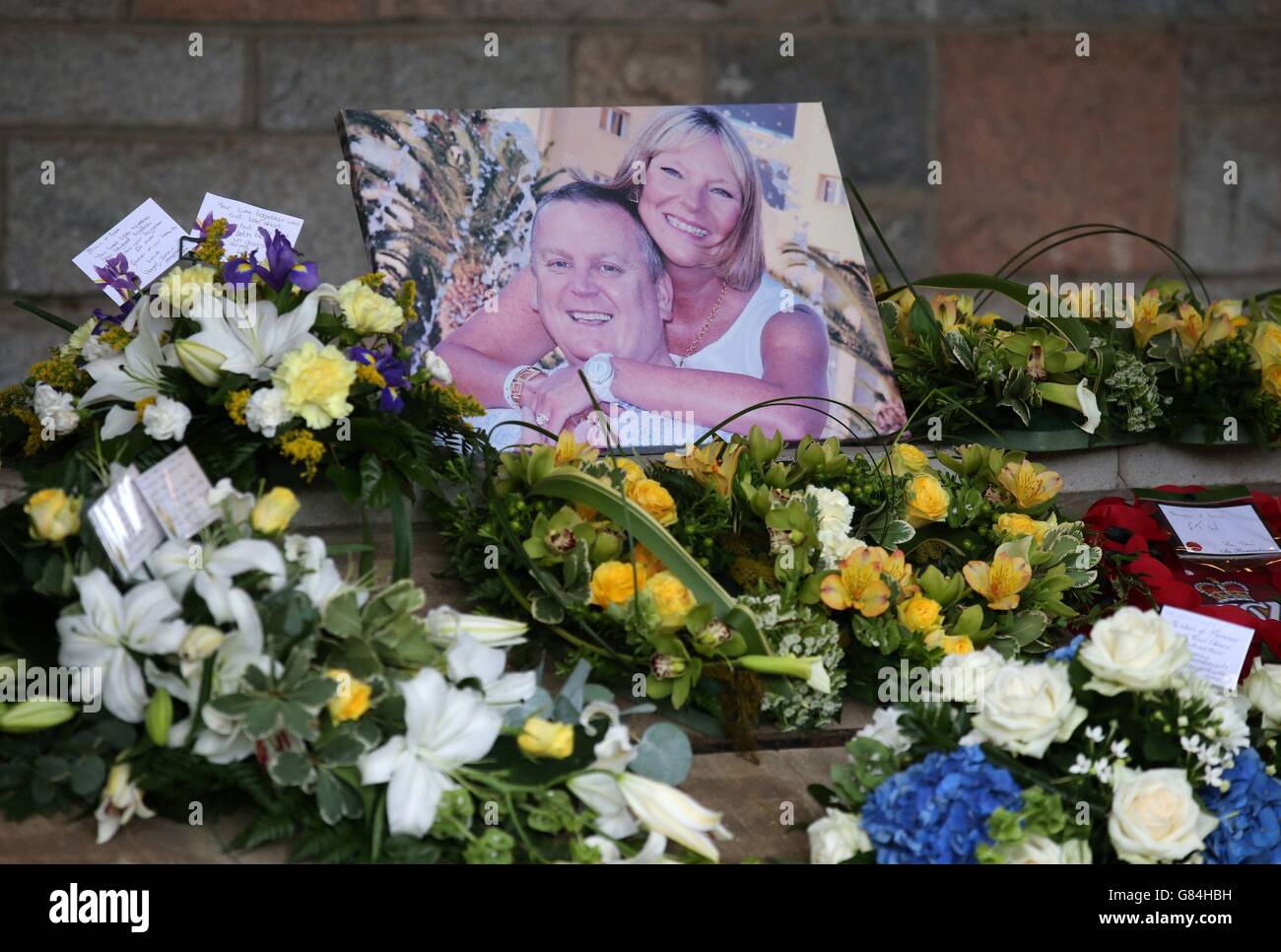 A photograph of Billy and Lisa Graham sits beside flowers at their ...