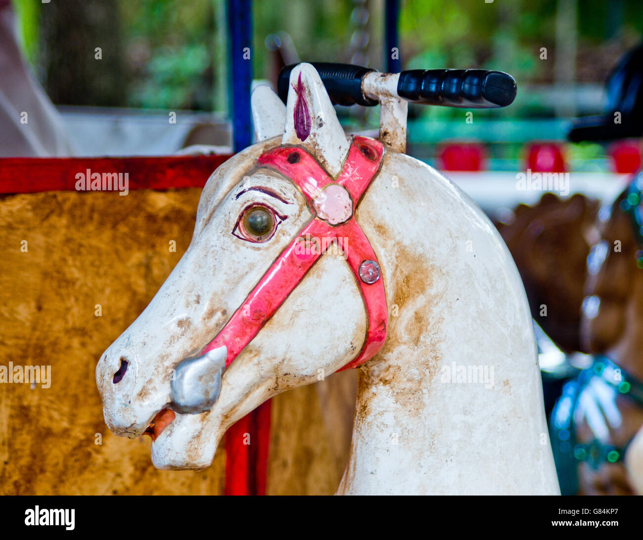 old horse of a colorful carousel of tan, red and blue Stock Photo - Alamy
