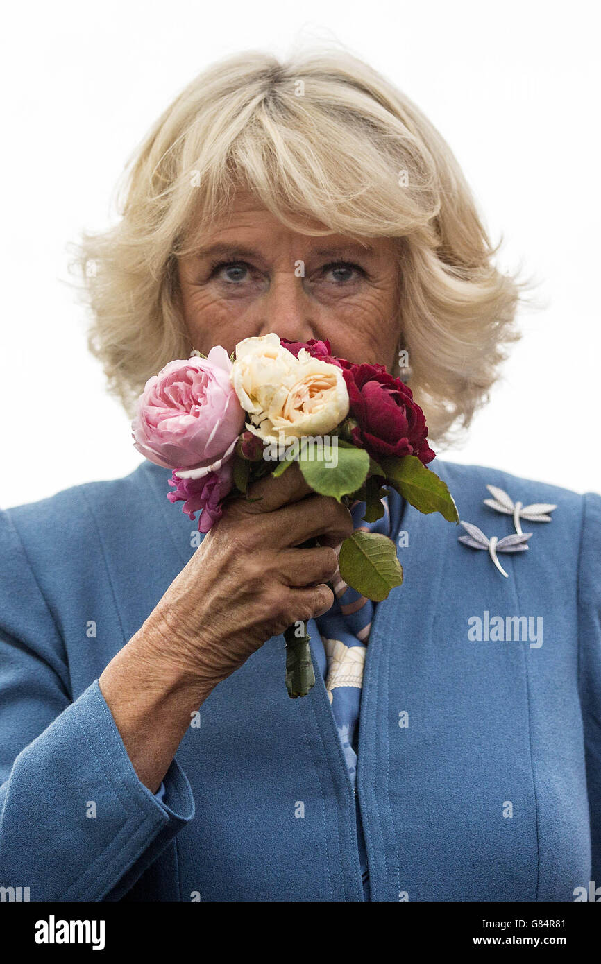 The Duchess of Cornwall sniffs roses as she and the Prince of Wales ...