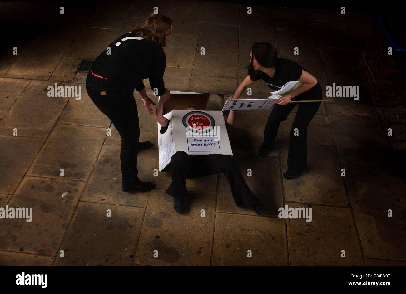 A protester struggles with her 'cigarette box' costume during a ...