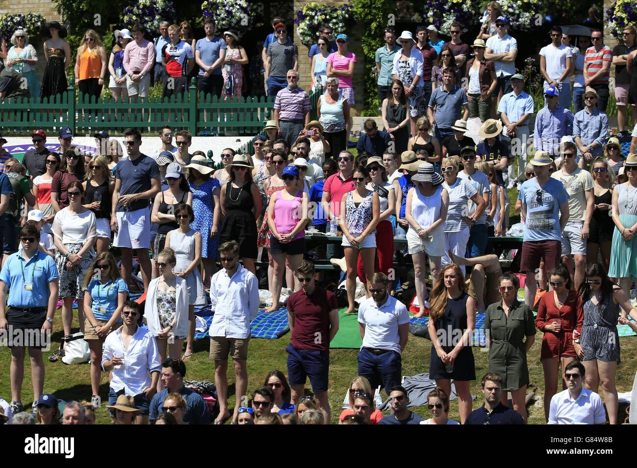 Spectators stand during minutes silence at the wimbledon tennis ...