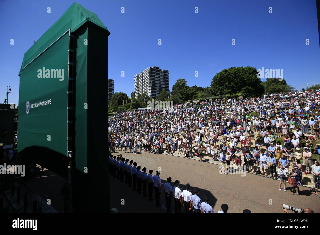 Spectators stand during minutes silence at the wimbledon tennis ...