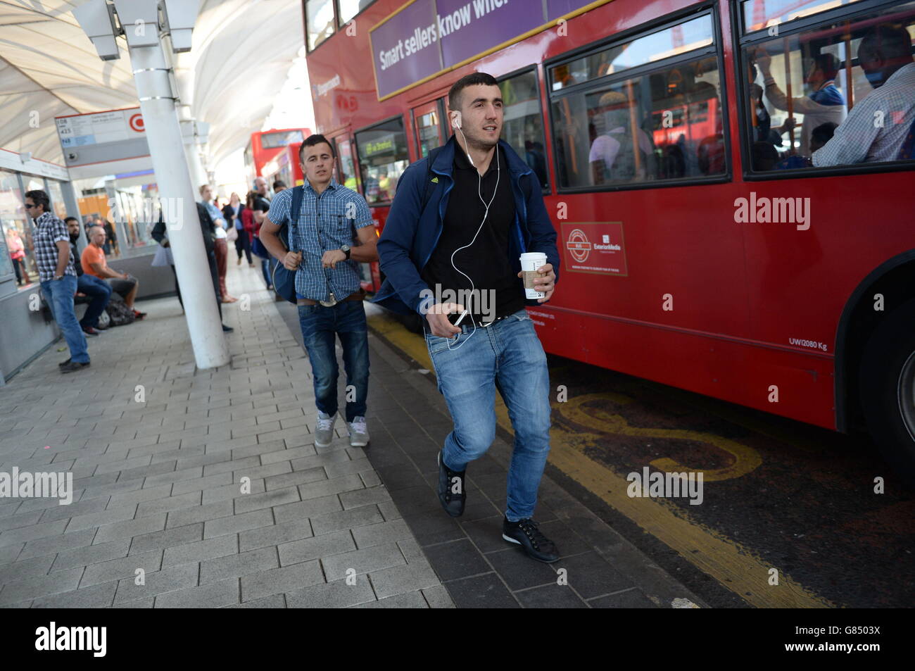 People dash for a bus at Stratford station, London, as commuters face ...