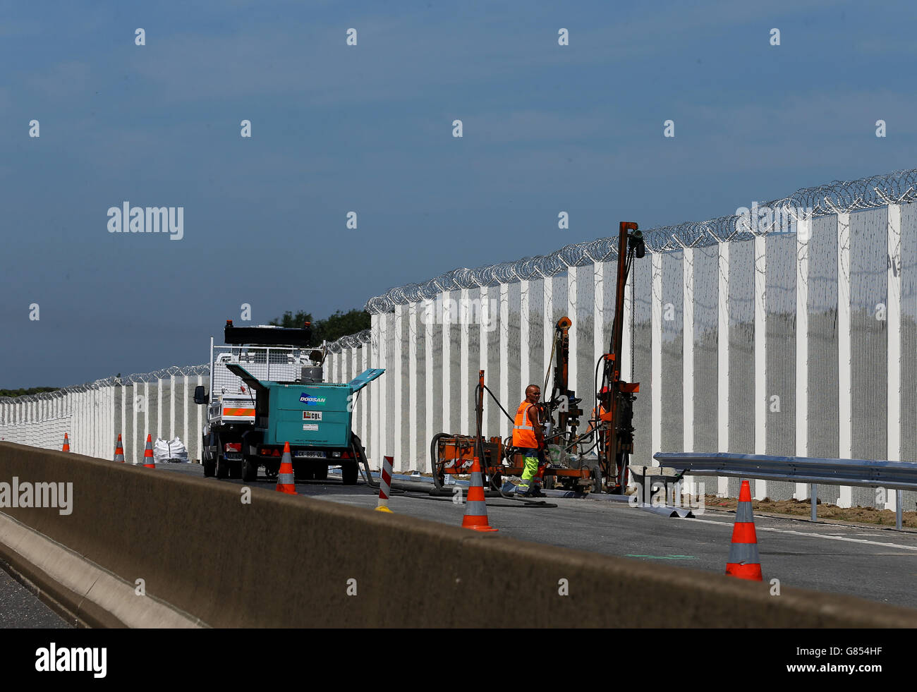 Workers install security fencing along the route into the ferry port in ...