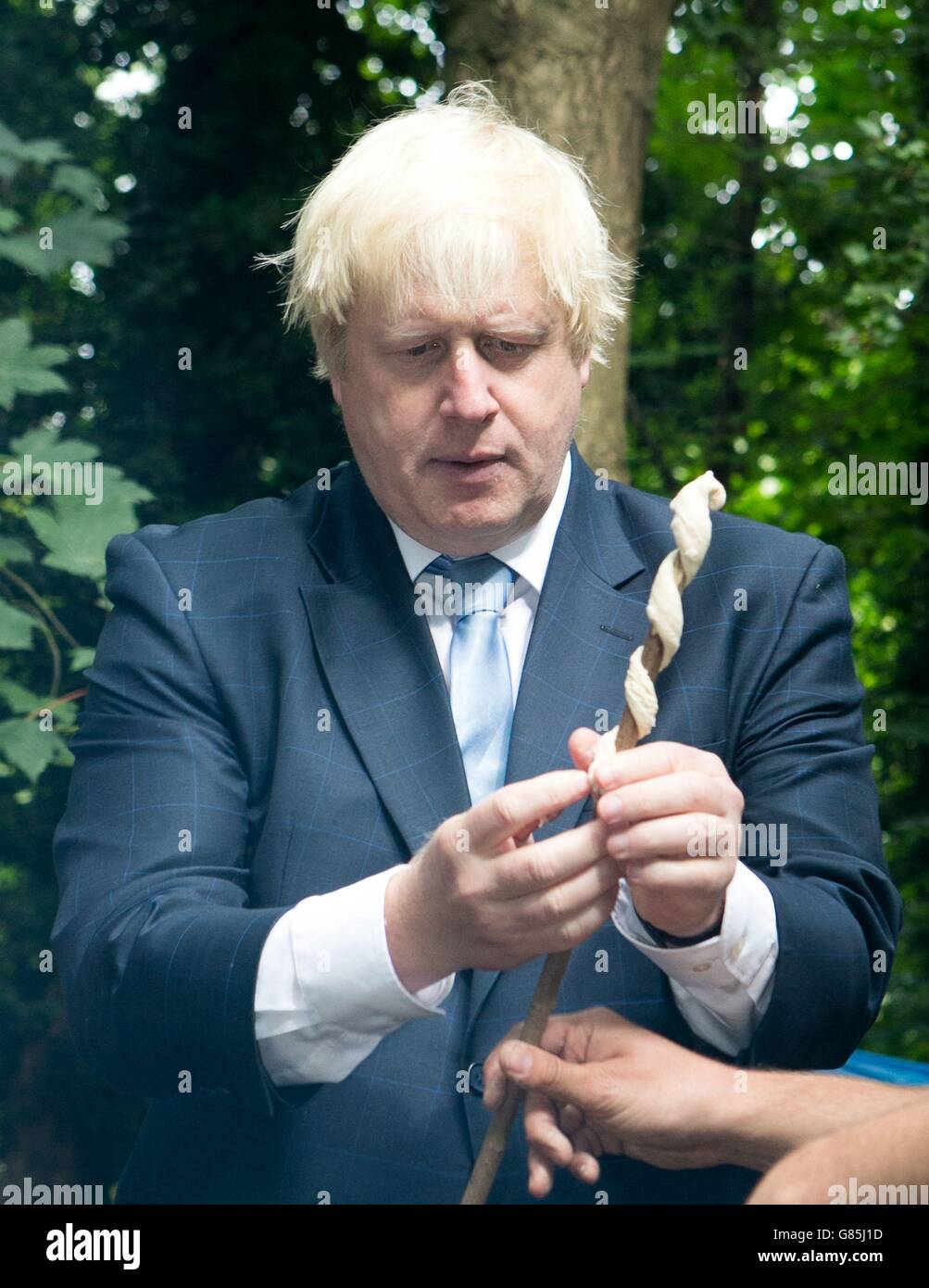 Mayor of London Boris Johnson wraps bread around a stick ahead of ...